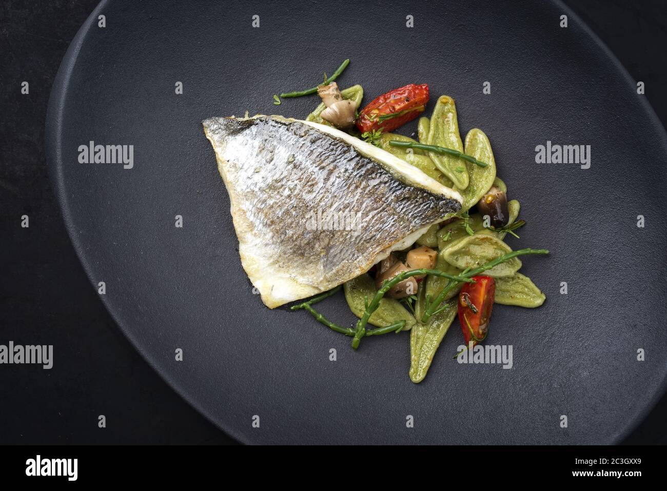 Gourmet fried Italian gilthead fish filet with spinach pasta Stock ...