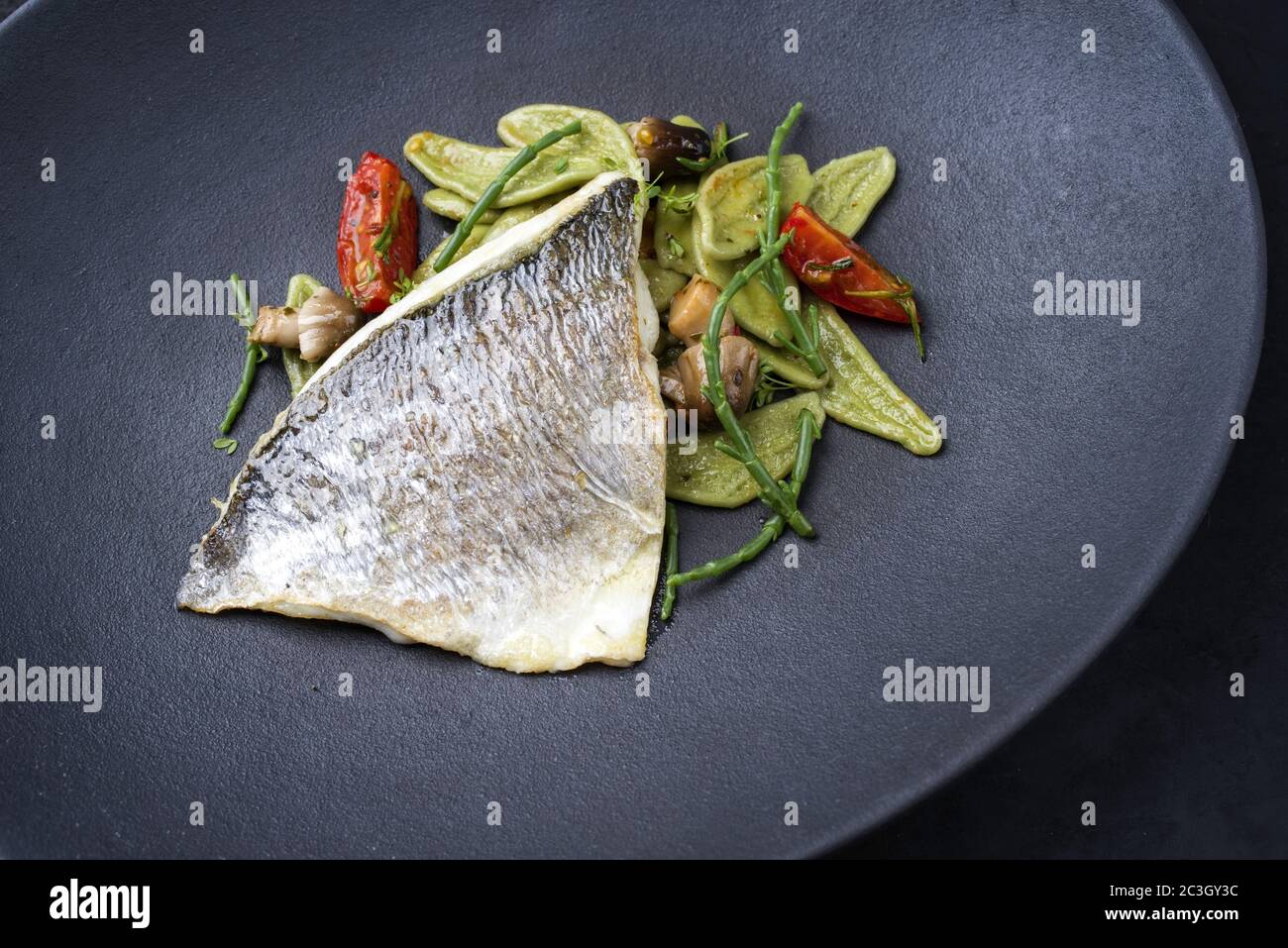 Gourmet fried Italian gilthead fish filet with spinach pasta Stock ...