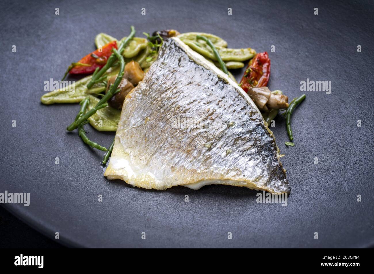 Gourmet fried Italian gilthead fish filet with spinach pasta Stock ...