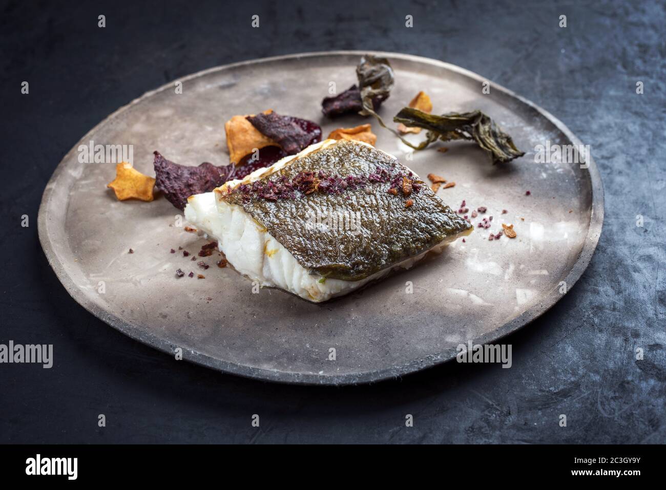 Gourmet fried European skrei cod fish filet with algae and vegetable ...