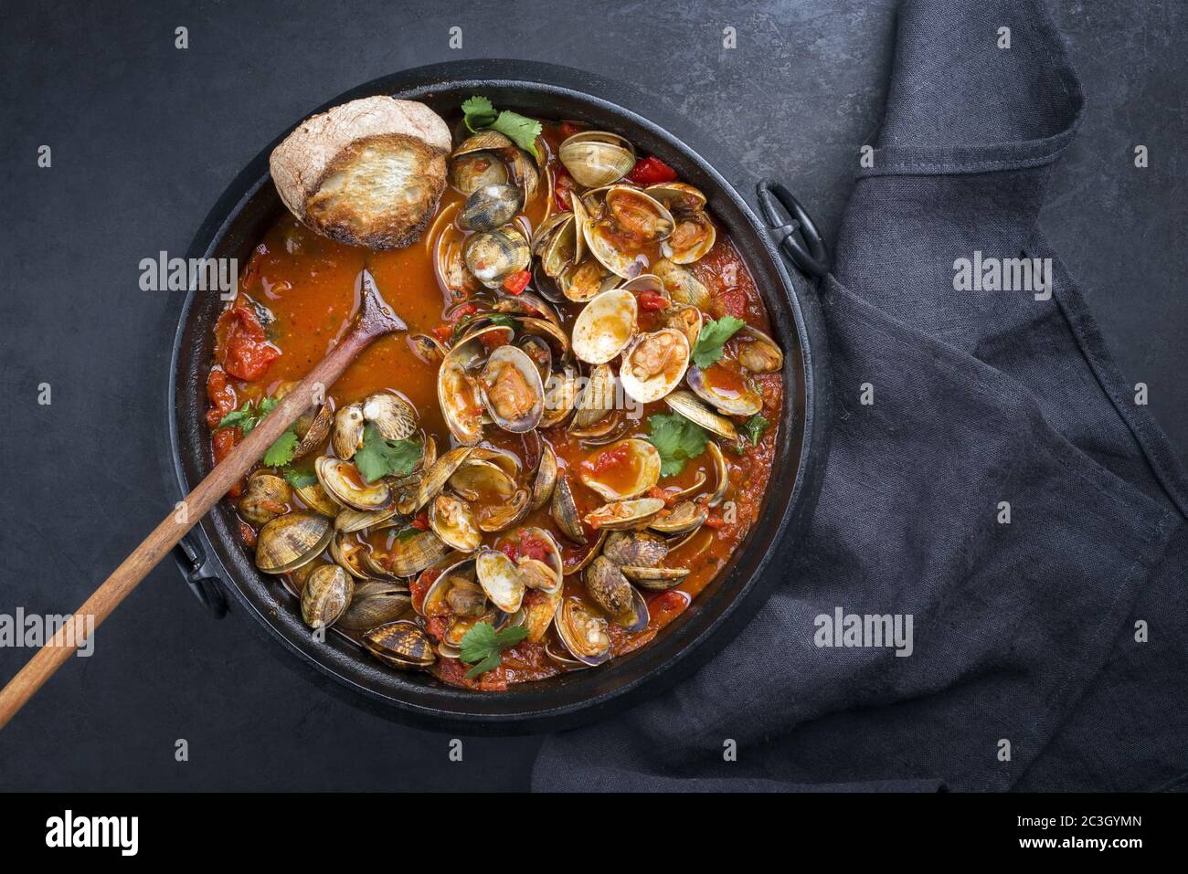 Cooked Japanese carpet shell with paprika and baguette in spicy tomato ...