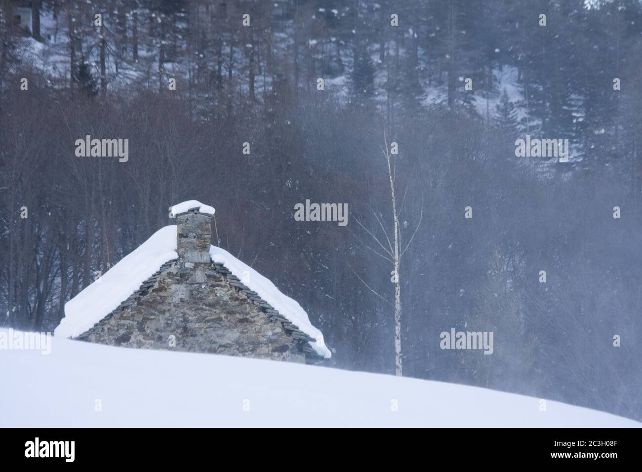 View of a concrete cabin covered with snow in the mountain during ...