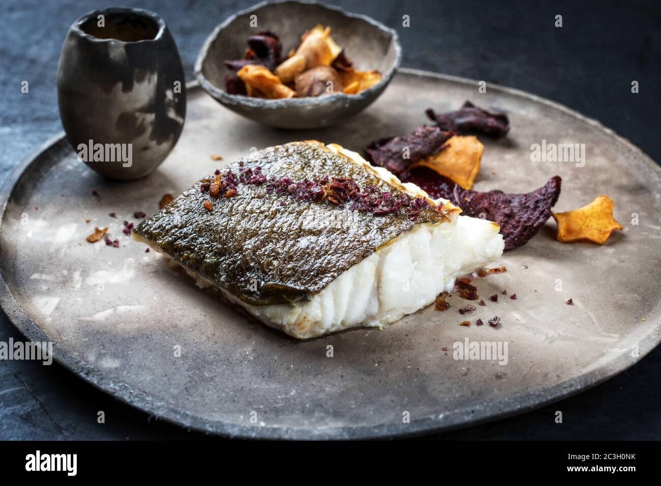 Gourmet fried European skrei cod fish filet with algae and vegetable ...