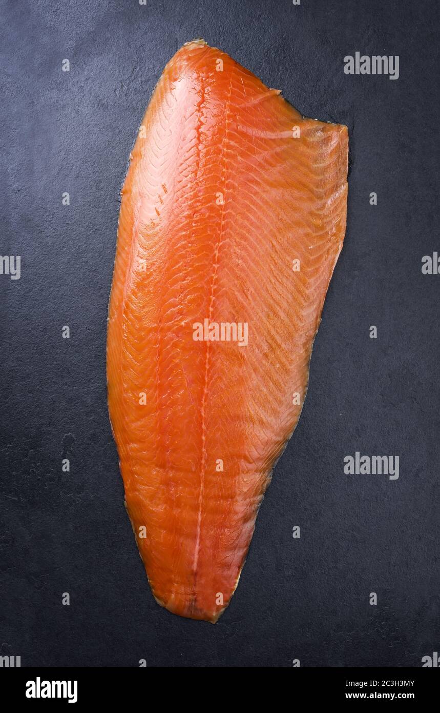 Traditional fresh smoked salmon fillet offered as top view on a black ...