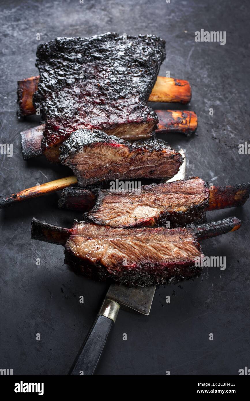 Barbecue burnt chuck beef ribs marinated and sliced as closeup on an ...