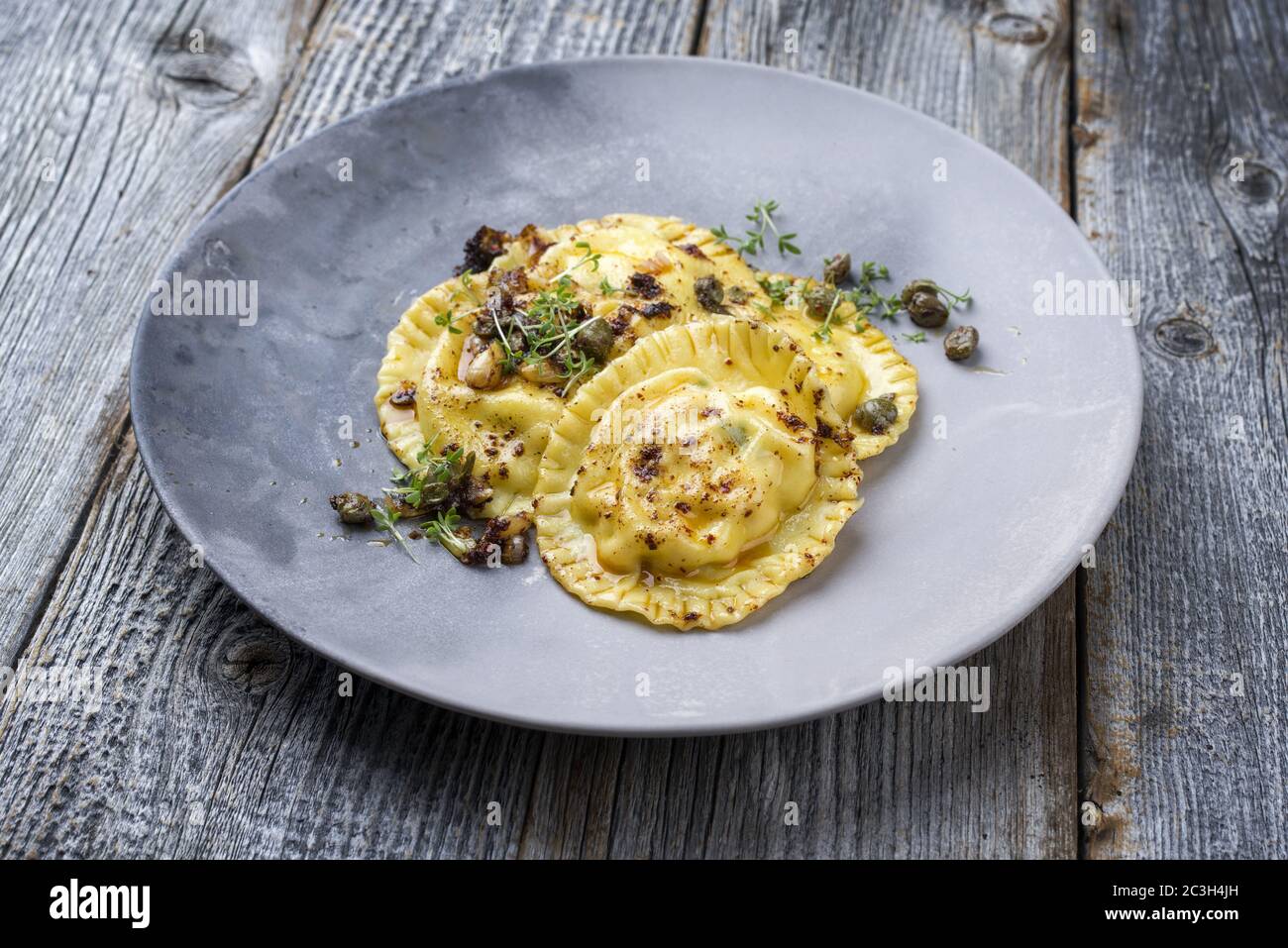 Traditional Italian ravioli pasta offered with capers and onion chili ...