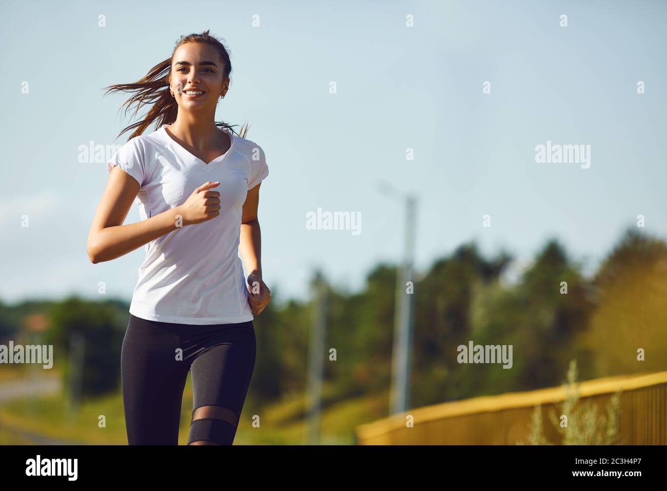 Girl runner runs along the road Stock Photo - Alamy