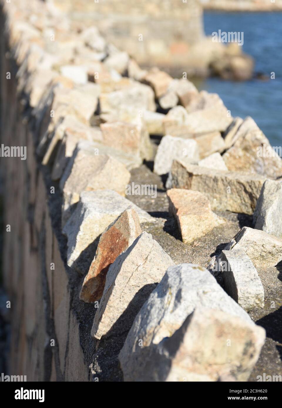 Sharp jagged rocks along the top edge of a retaining wall Stock Photo ...