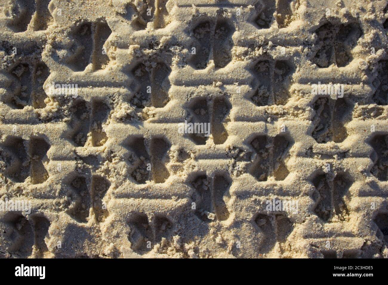 Footprint in the sand from a car tire or quadro cycle at sunrise on a ...