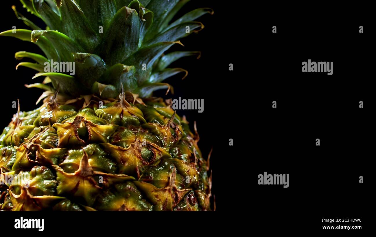 Juicy fresh big pineapple rotating on black background. Fruit isolated ...