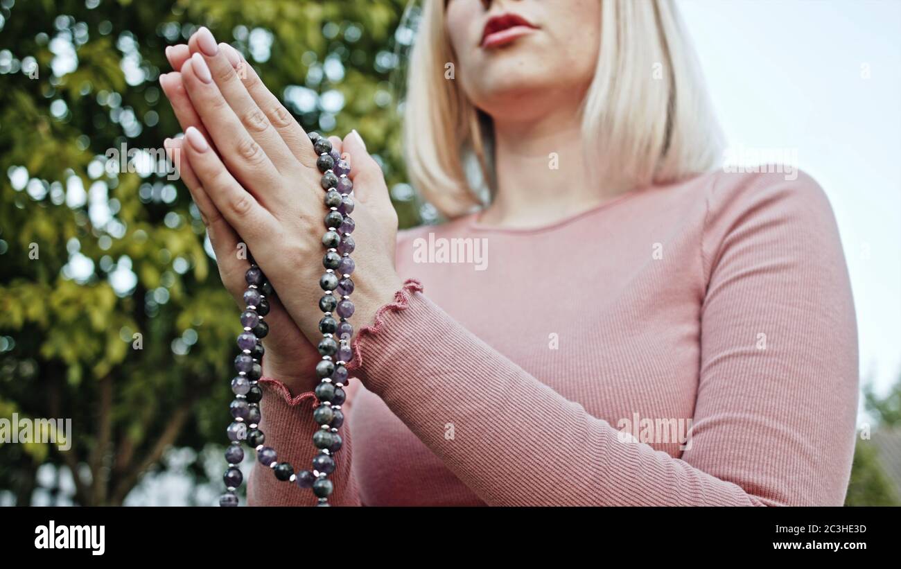Woman's hands with mala beads or rosary together symbolizing prayer and ...