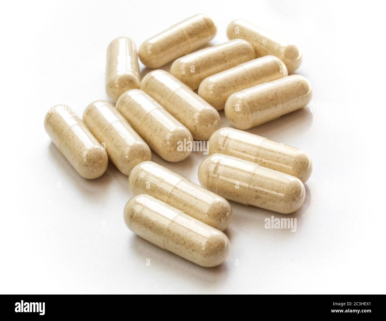 Group of brown capsules spilled on white Stock Photo - Alamy