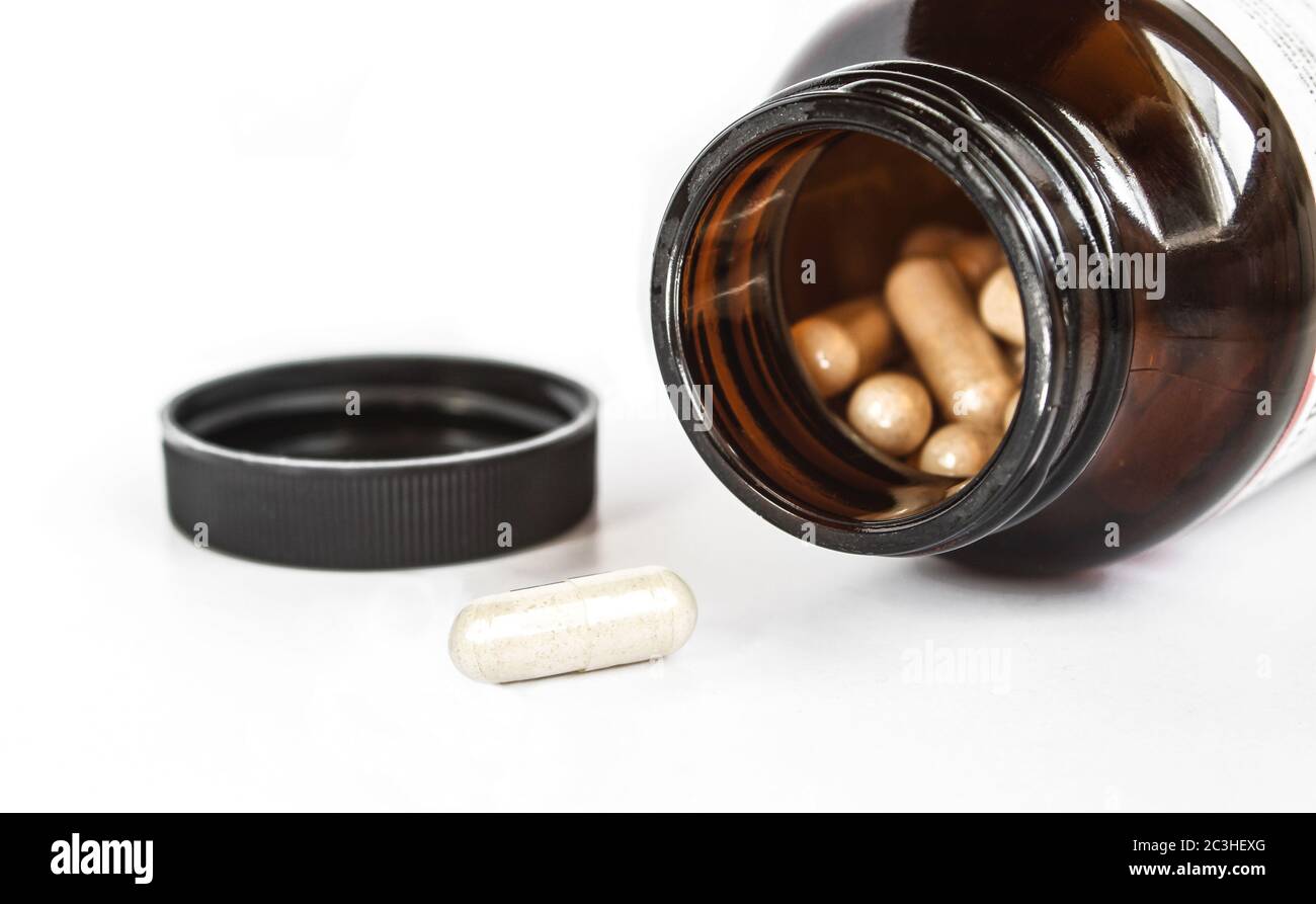 One pill out of plastic bottle and bunch inside. Spilled capsule ...