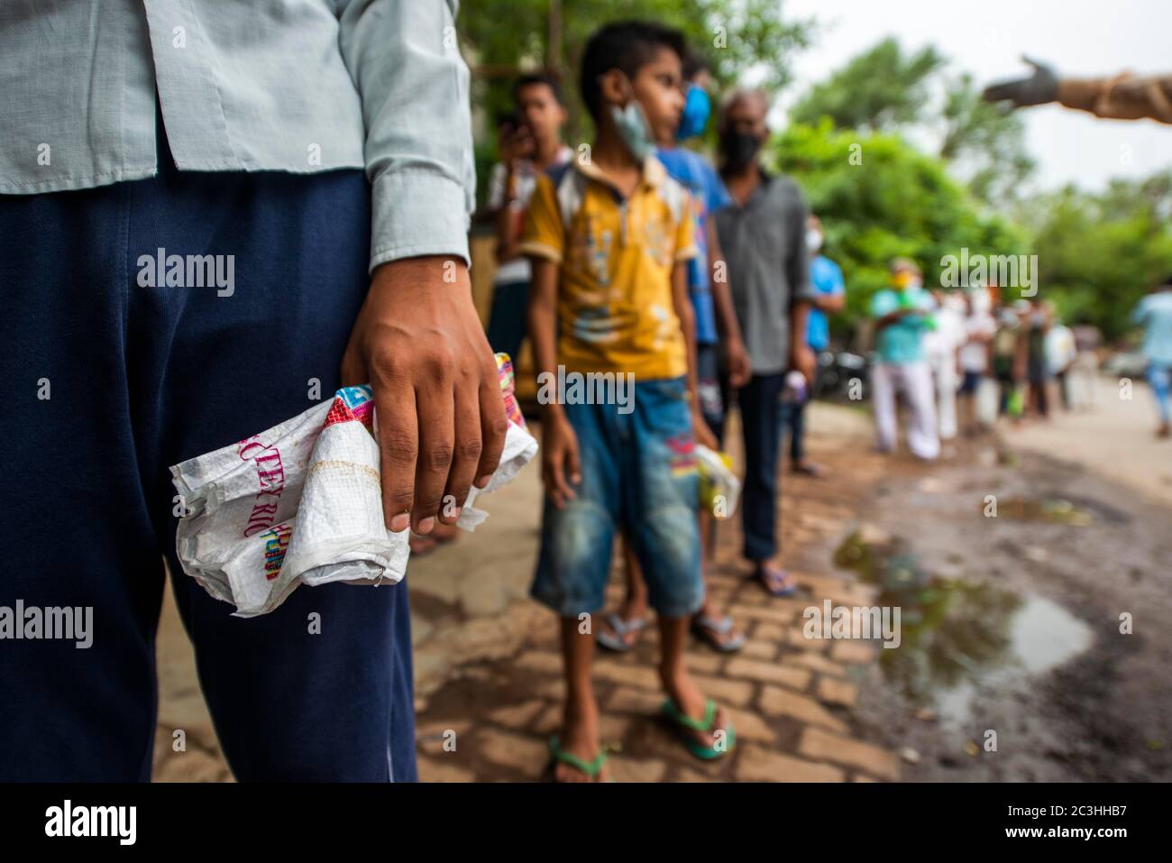 A man waiting in queue is seen carrying a bag for his portion of the ...