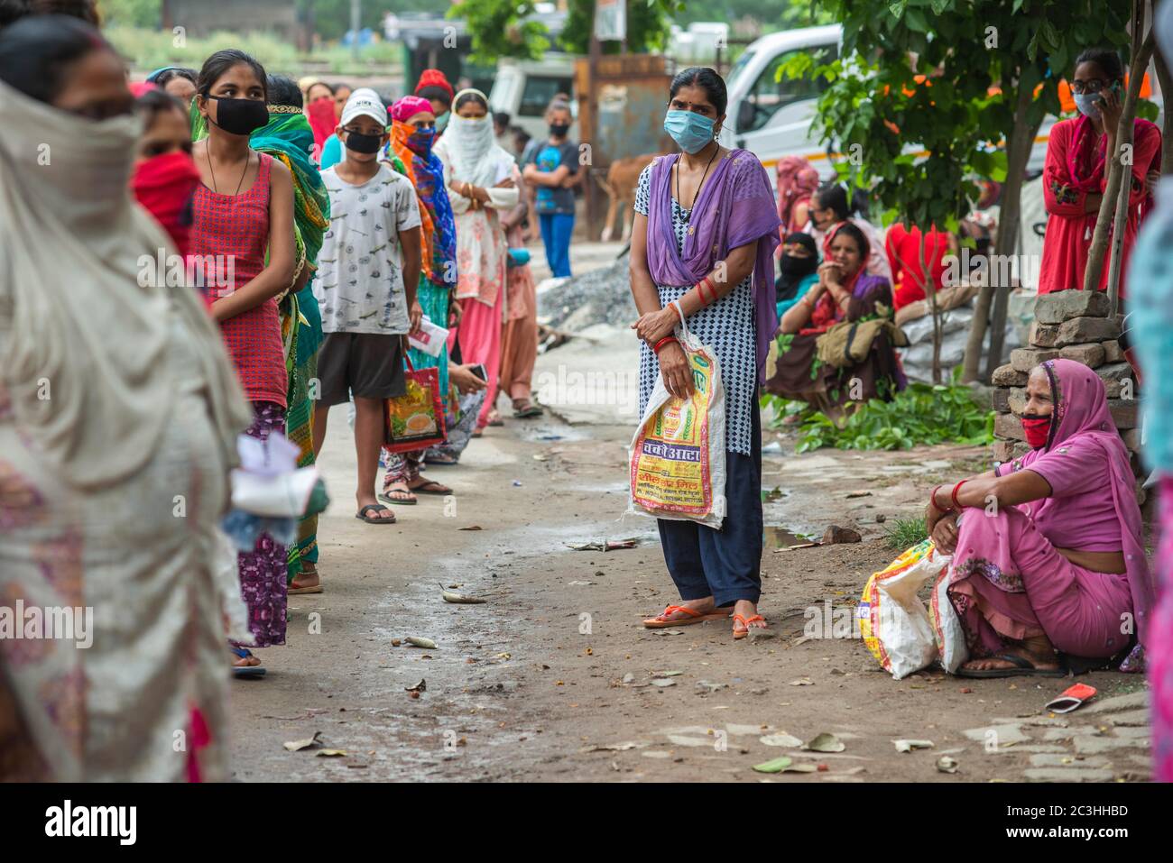 People patiently standing in queue amidst the process of receiving free ...