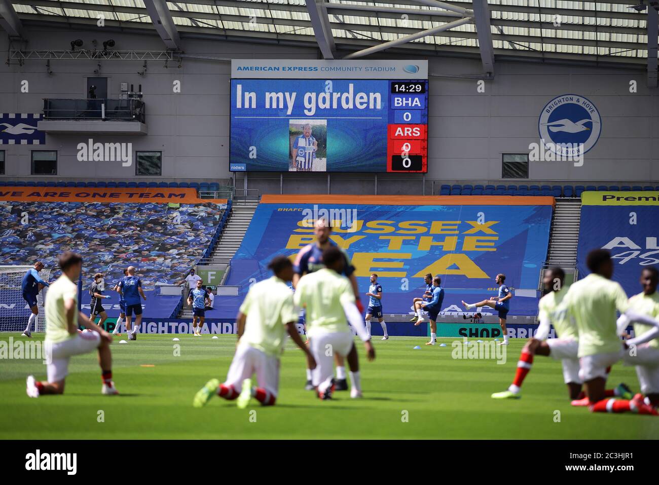 Players warm up as Brighton fans are shown on the big screen during the ...