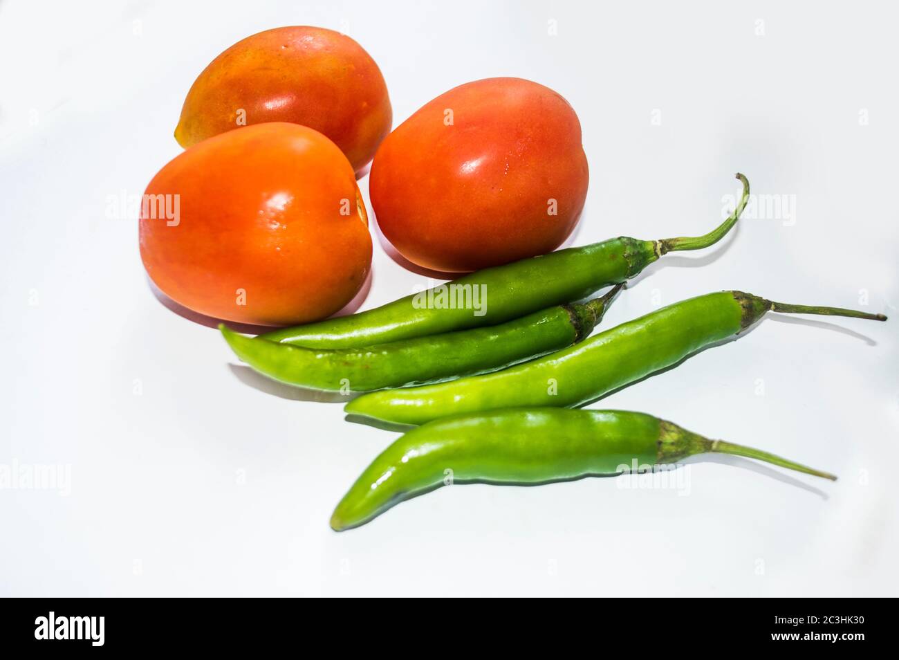 Tomato and chilli isolated on a white background Stock Photo - Alamy