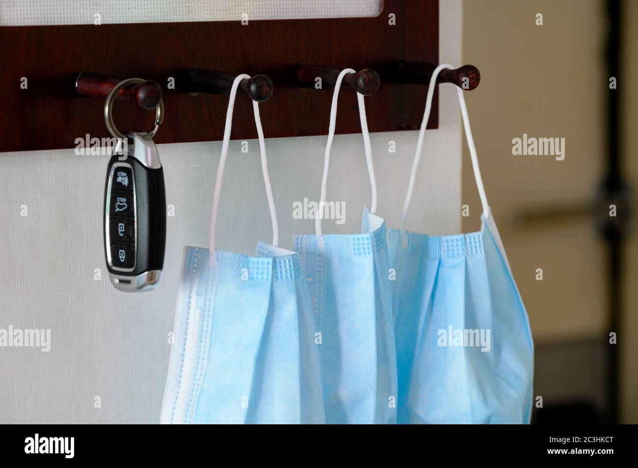Car keys and a medical face mask hang on a key hanger rack Stock Photo ...