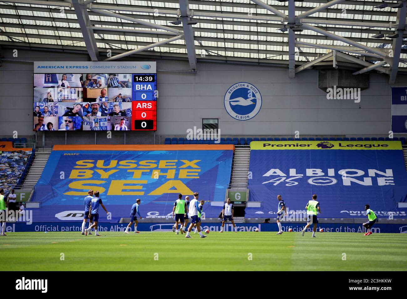 Players warm up as Brighton fans are shown on the big screen during the ...