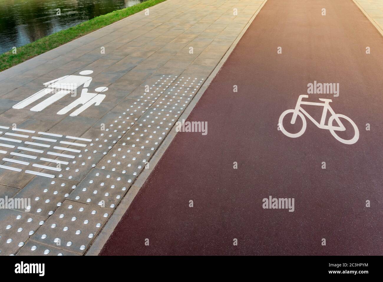 Traffic signs on bicycle path and sidewalk for pedestrians near river ...