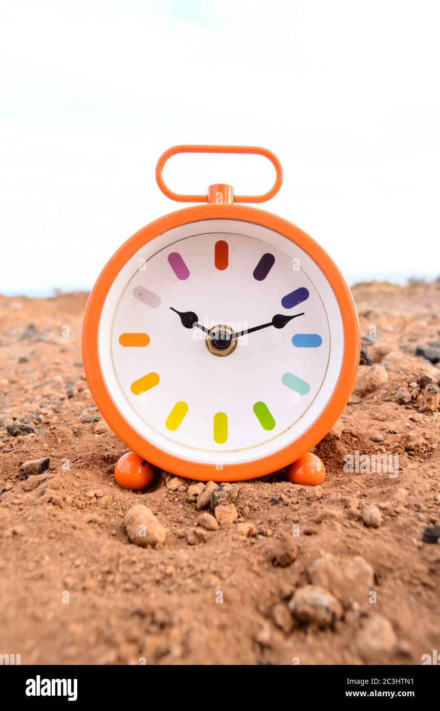 Classic Analog Clock In The Sand On The Rock Desert Stock Photo - Alamy