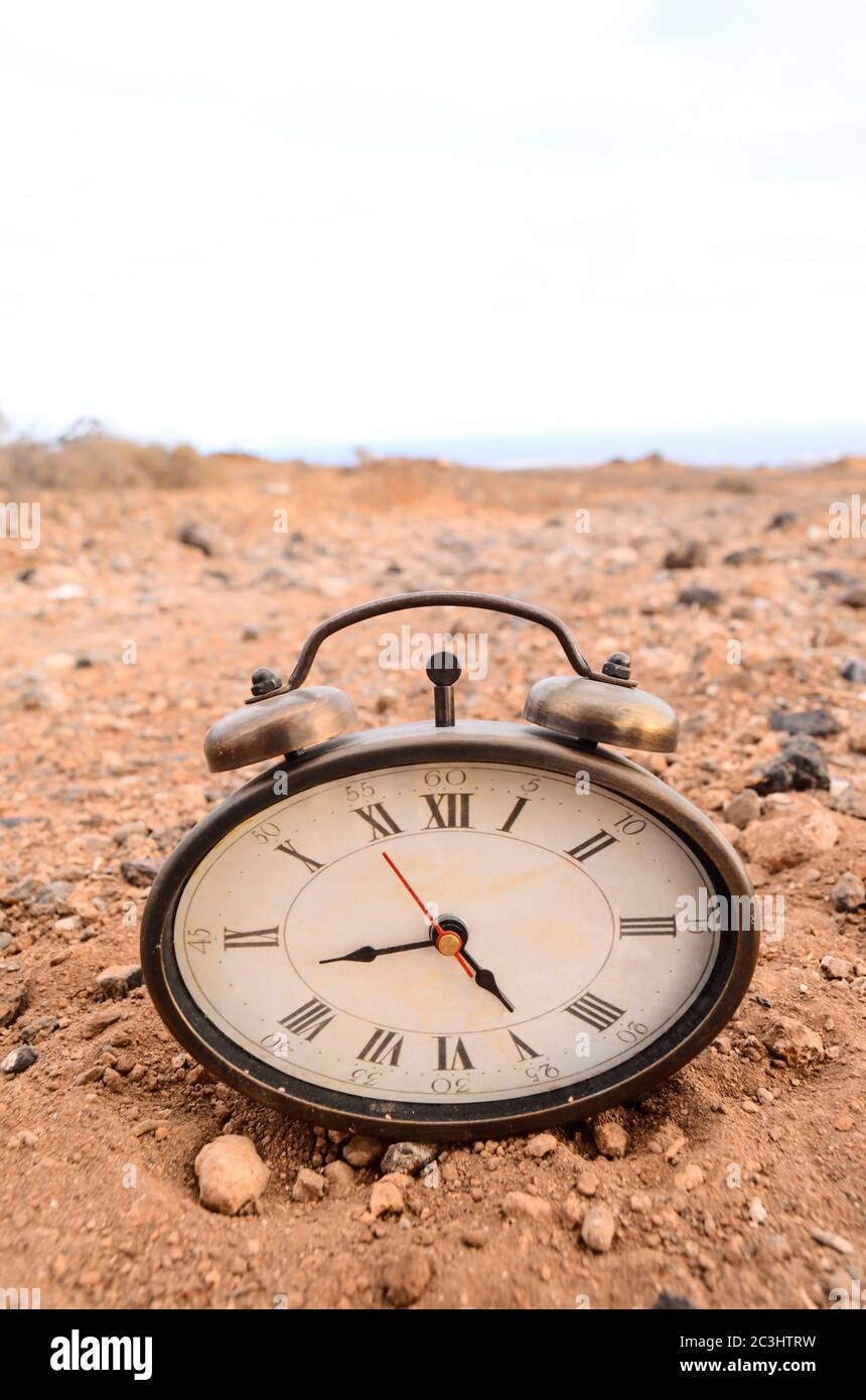 Classic Analog Clock In The Sand On The Rock Desert Stock Photo - Alamy