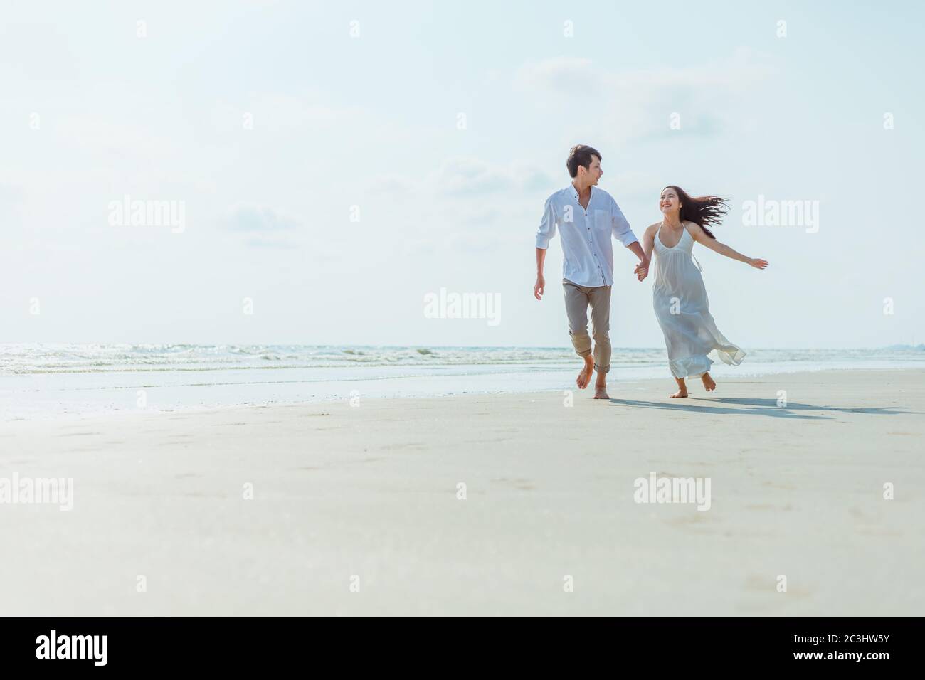 Romantic couple holding hands running and walking on beach. Man and ...