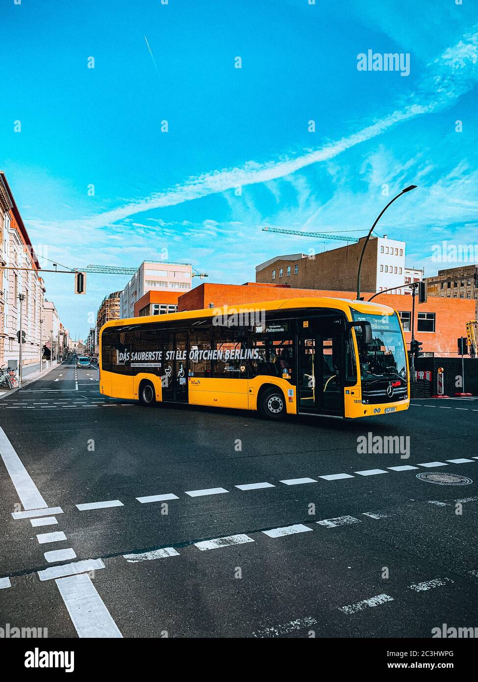Vertical shot of a yellow bus on an empty street under the beautiful ...