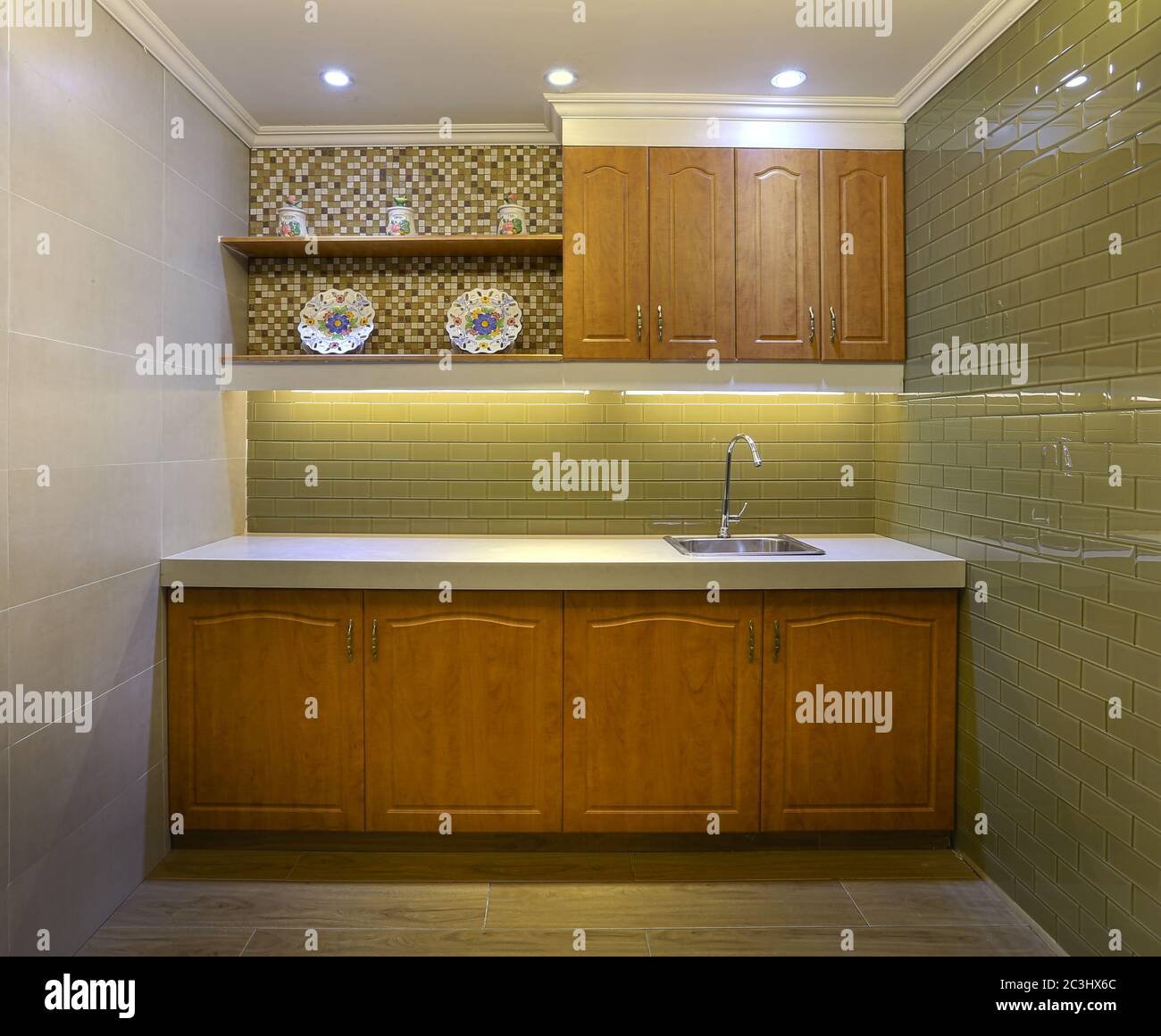 Beautiful and neat kitchen with wooden cabinets with plates on the ...