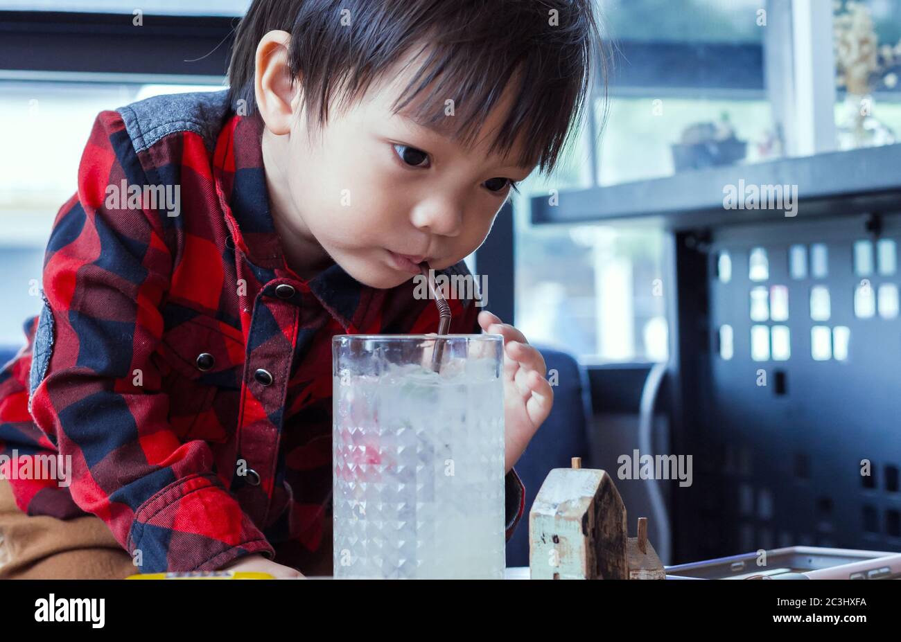 A child drinking water from straw Stock Photo - Alamy