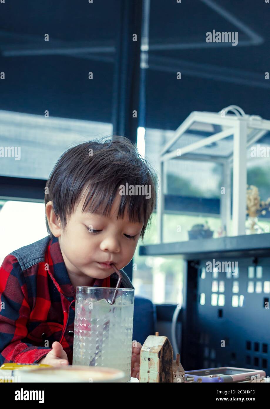 A child drinking water from straw Stock Photo - Alamy