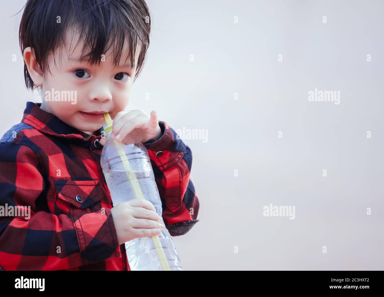 A children drinking water from straw Stock Photo - Alamy