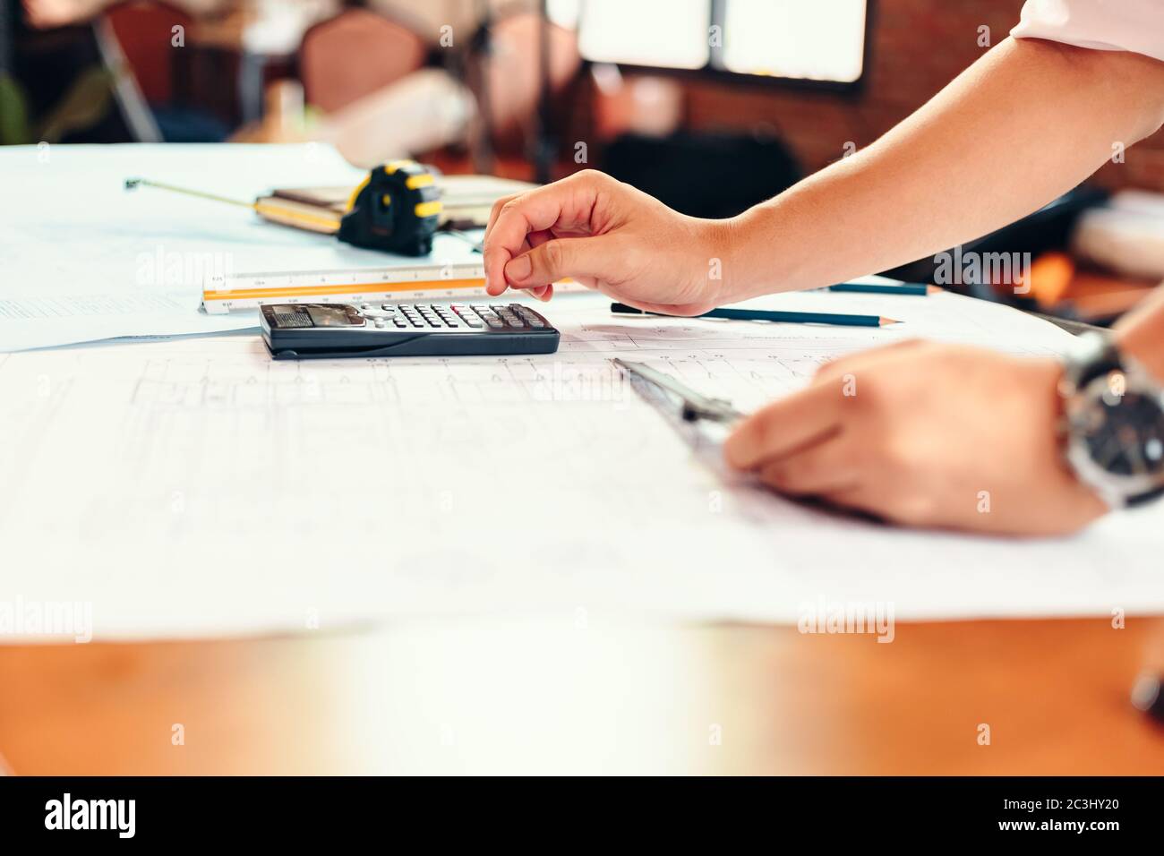 Engineering Using Calculator For Accounting And Analyzing Building Structure From Blueprint