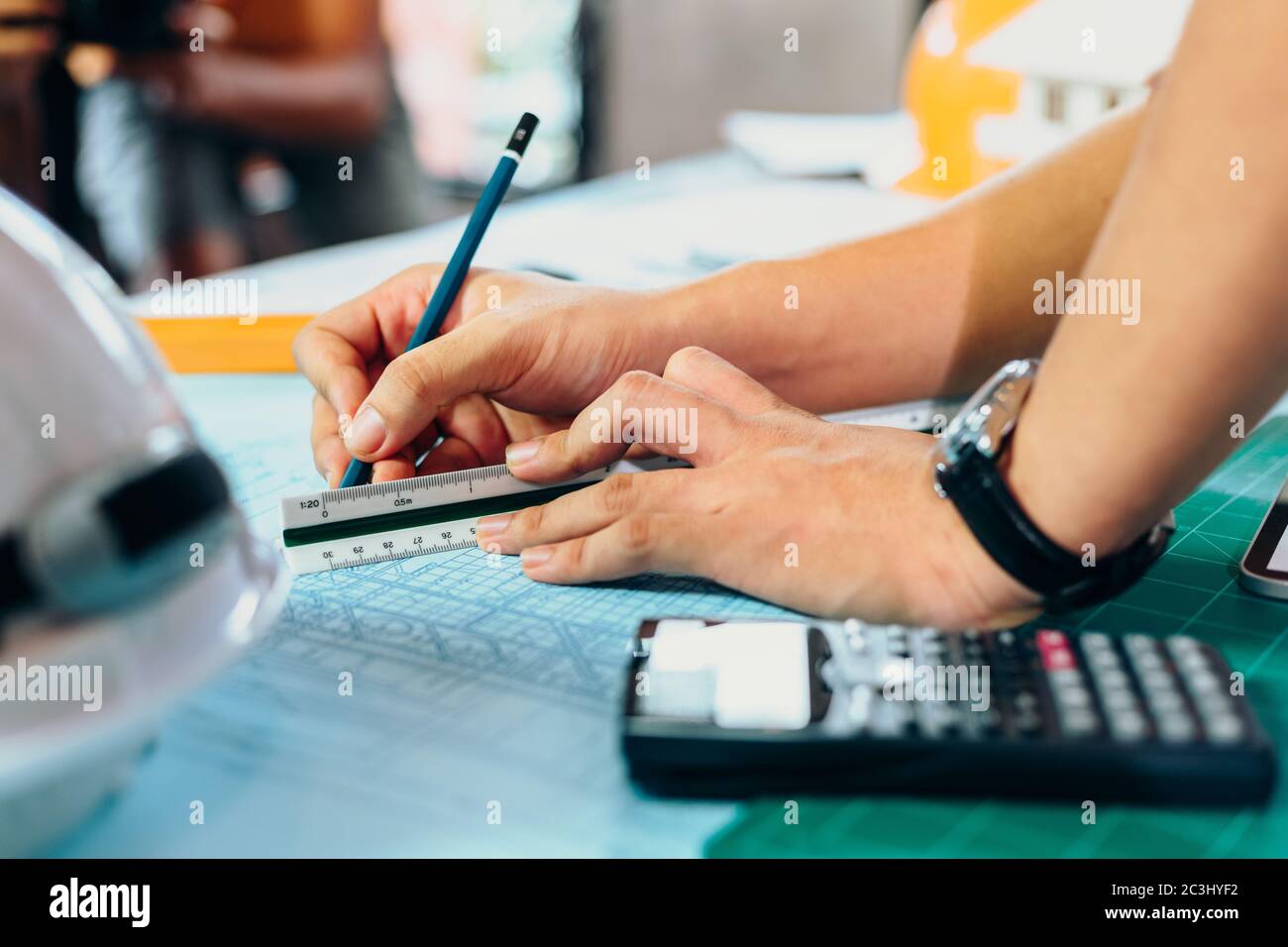 engineers holding a pen pointing to a building and drawing outlay ...
