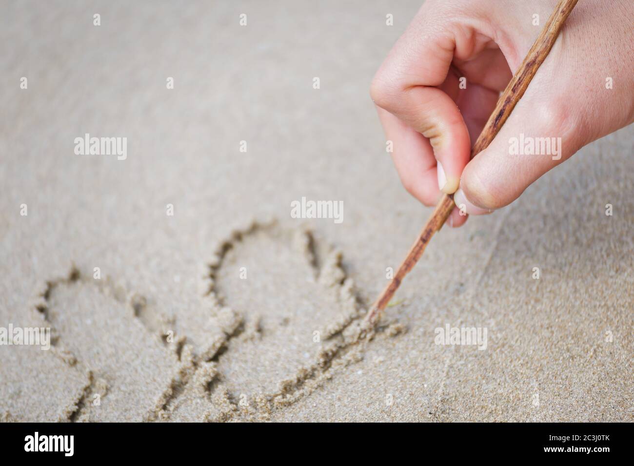 Hands writing on sand and water flow Stock Photo - Alamy