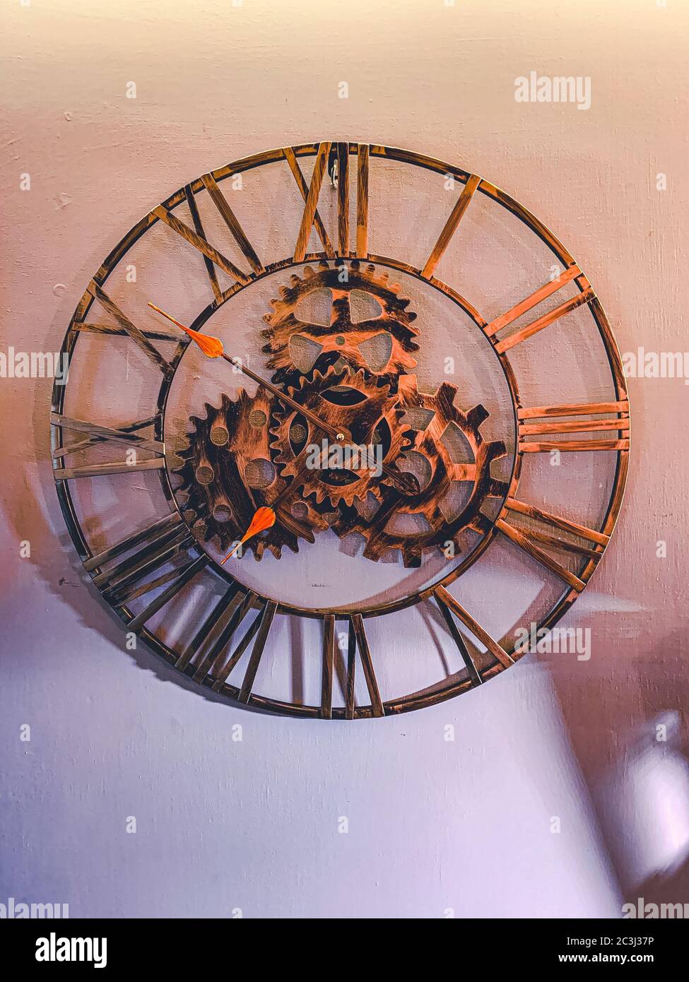 Closeup vertical shot of an old vintage clock hanging on the wall Stock ...