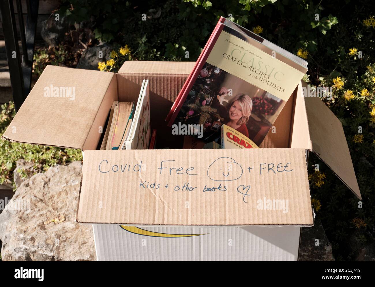 Box of free books on sidewalk with written text "Covid Free", reality ...