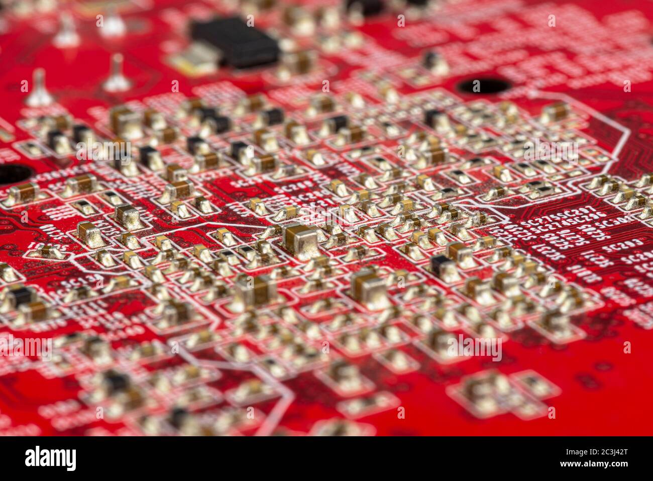 Macro photo of electrical paths on red circuit board, visible resistors ...