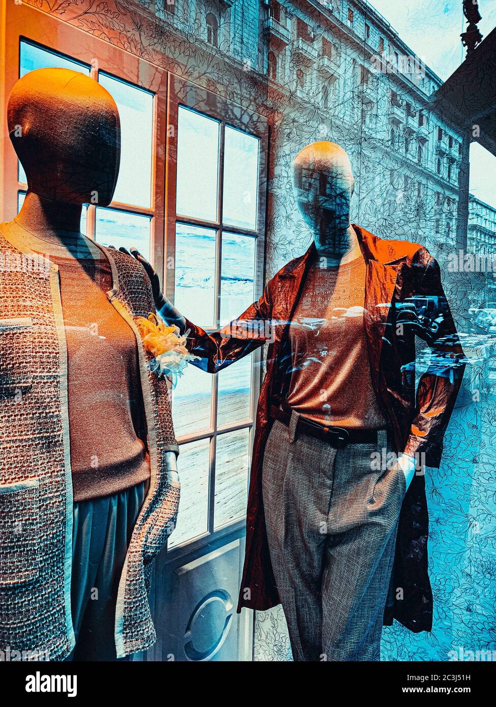 Closeup vertical shot of clothes mannequins visible through the shop ...