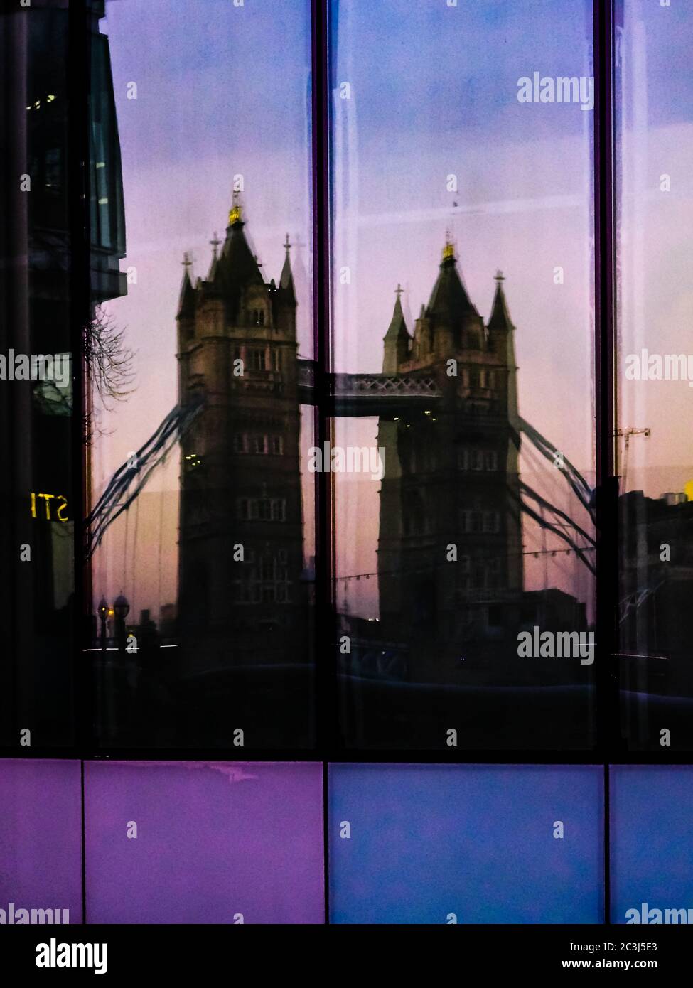 Vertical shot of Tower Bridge reflection in the glass building in ...