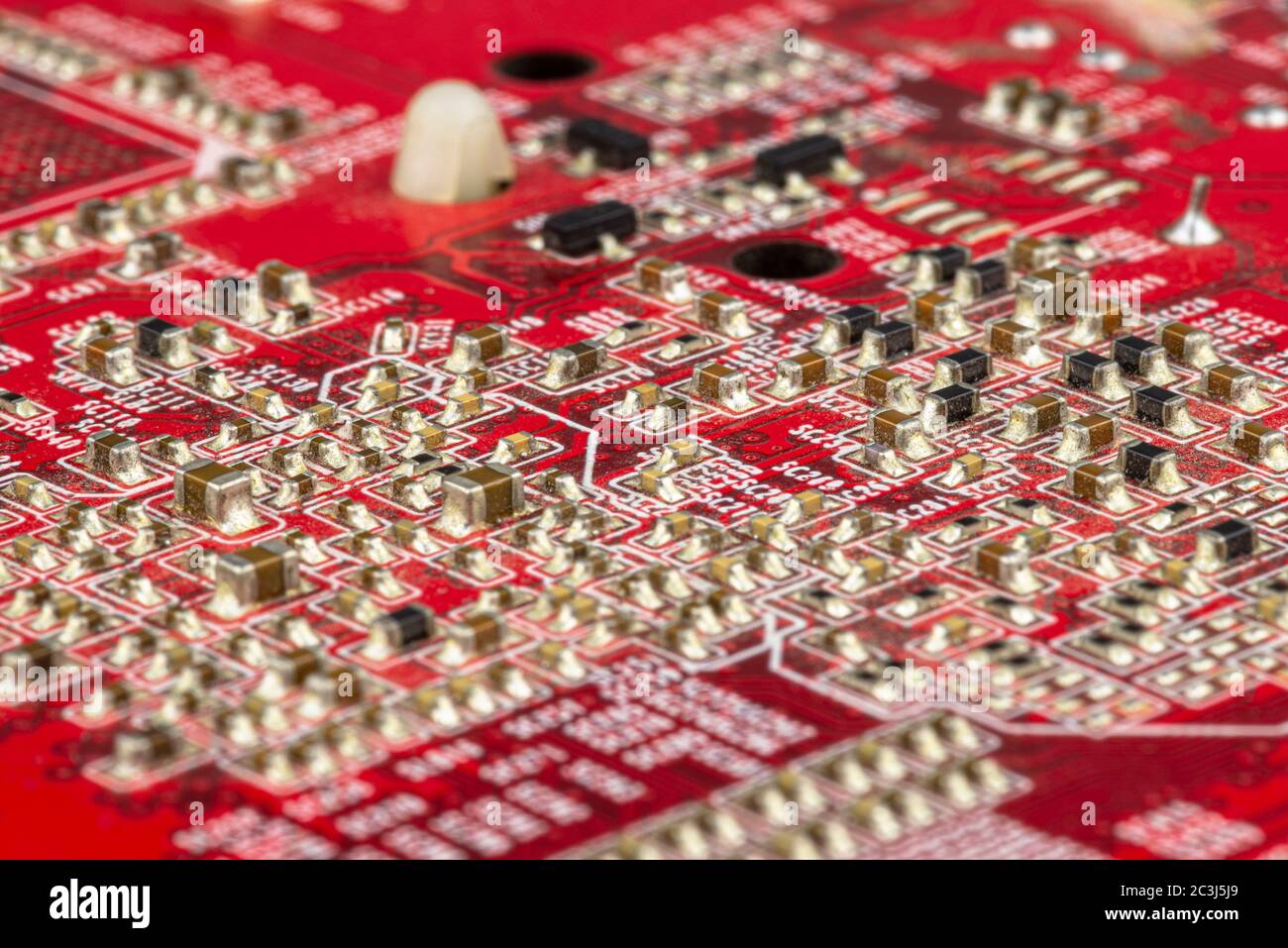 Macro photo of electrical paths on red circuit board, visible resistors ...