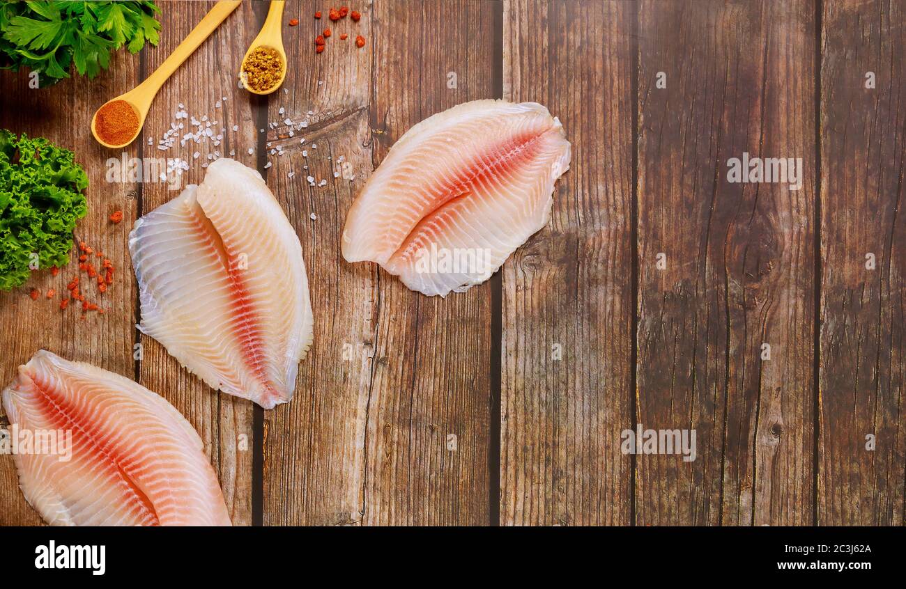 Organic fish tilapia on table with lemon and seasoning Stock Photo - Alamy