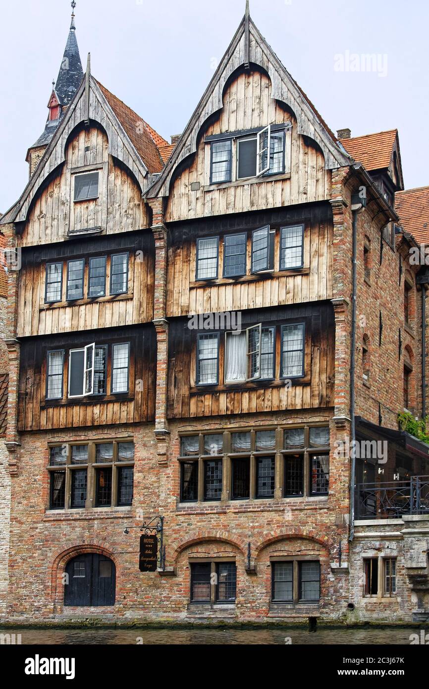 hotel, brick, partial wood facade, steep tile roof, buildings along ...