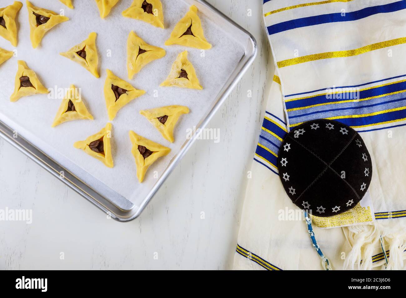 Uncooked jewish cookies on oven tray with kippa and tallit for Purim ...