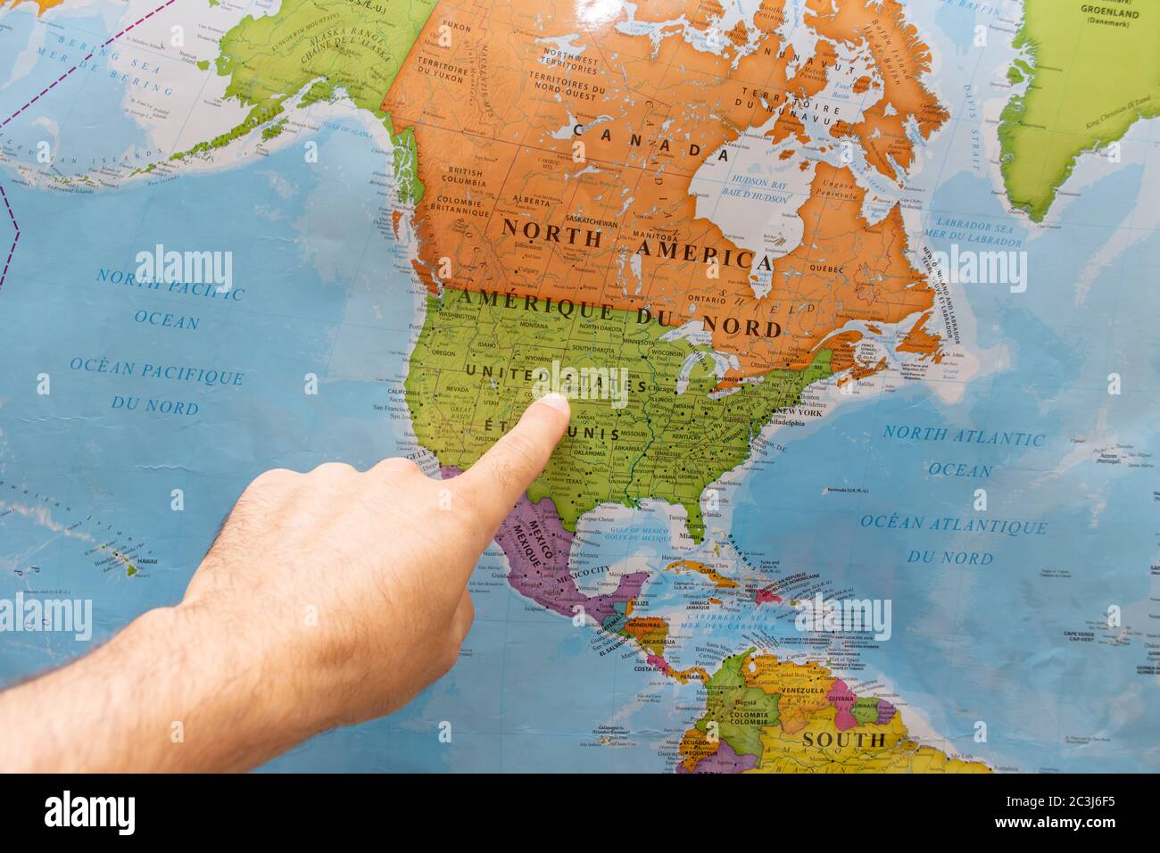 "RAK, RAK/UAE - 4/12/2020: Finger pointing to a colorful country map in ...