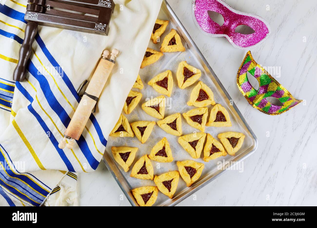 Jewish cookies Haman ears with jam in baking pan for Purim with mask ...