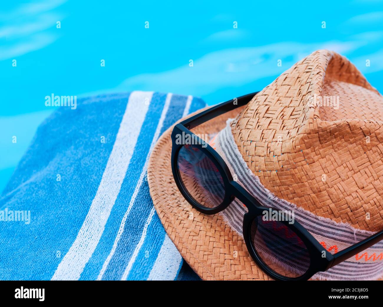 Vintage summer wicker straw beach hat, sun glasses, blue towel near ...