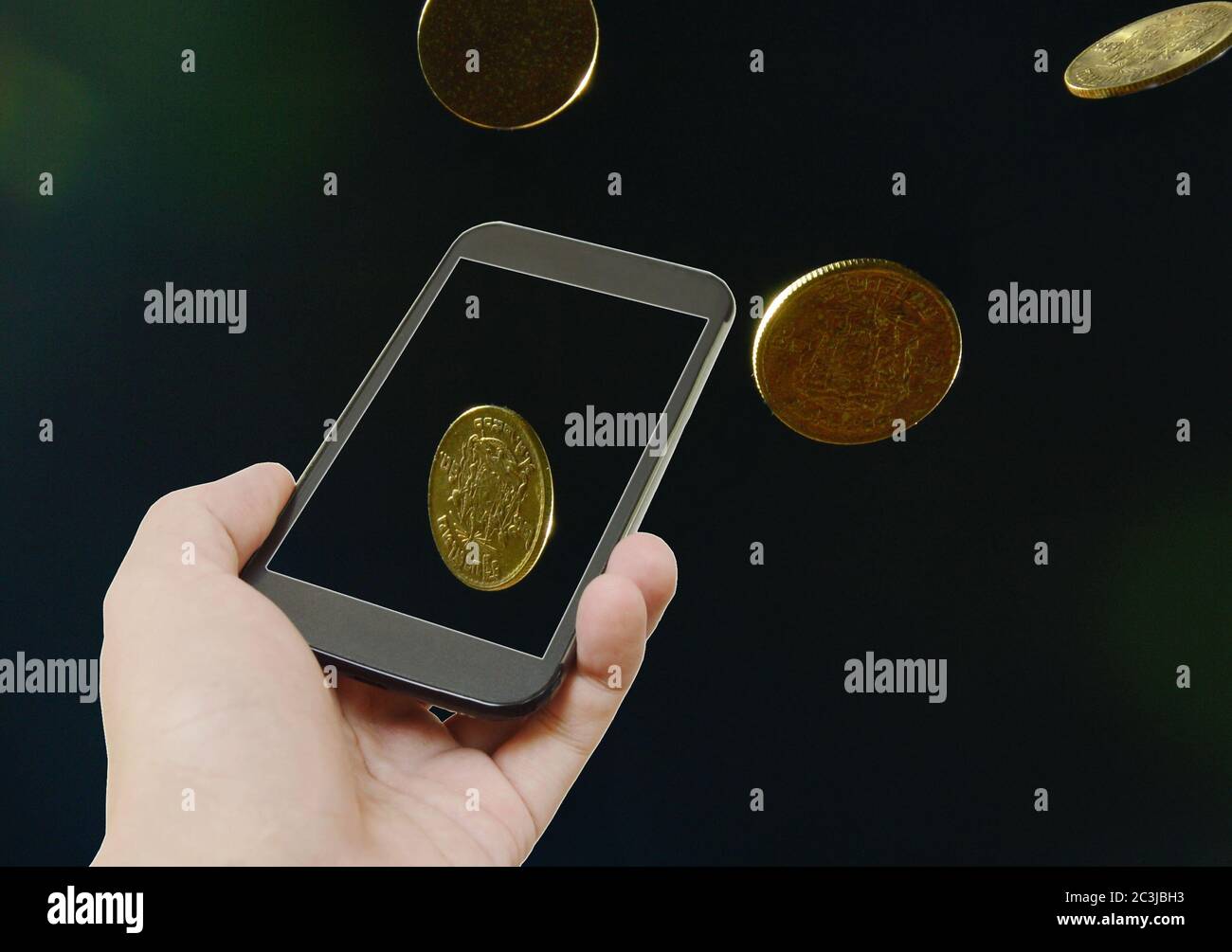 Hand holding smart phone and gold coin floating Stock Photo - Alamy