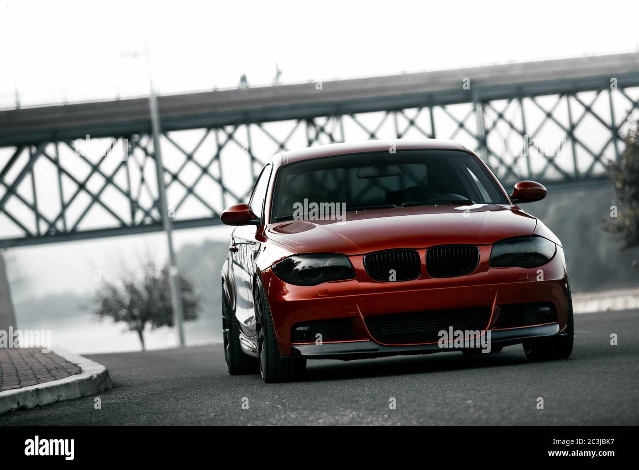 Red luxurious sedan car diving in the street Stock Photo - Alamy