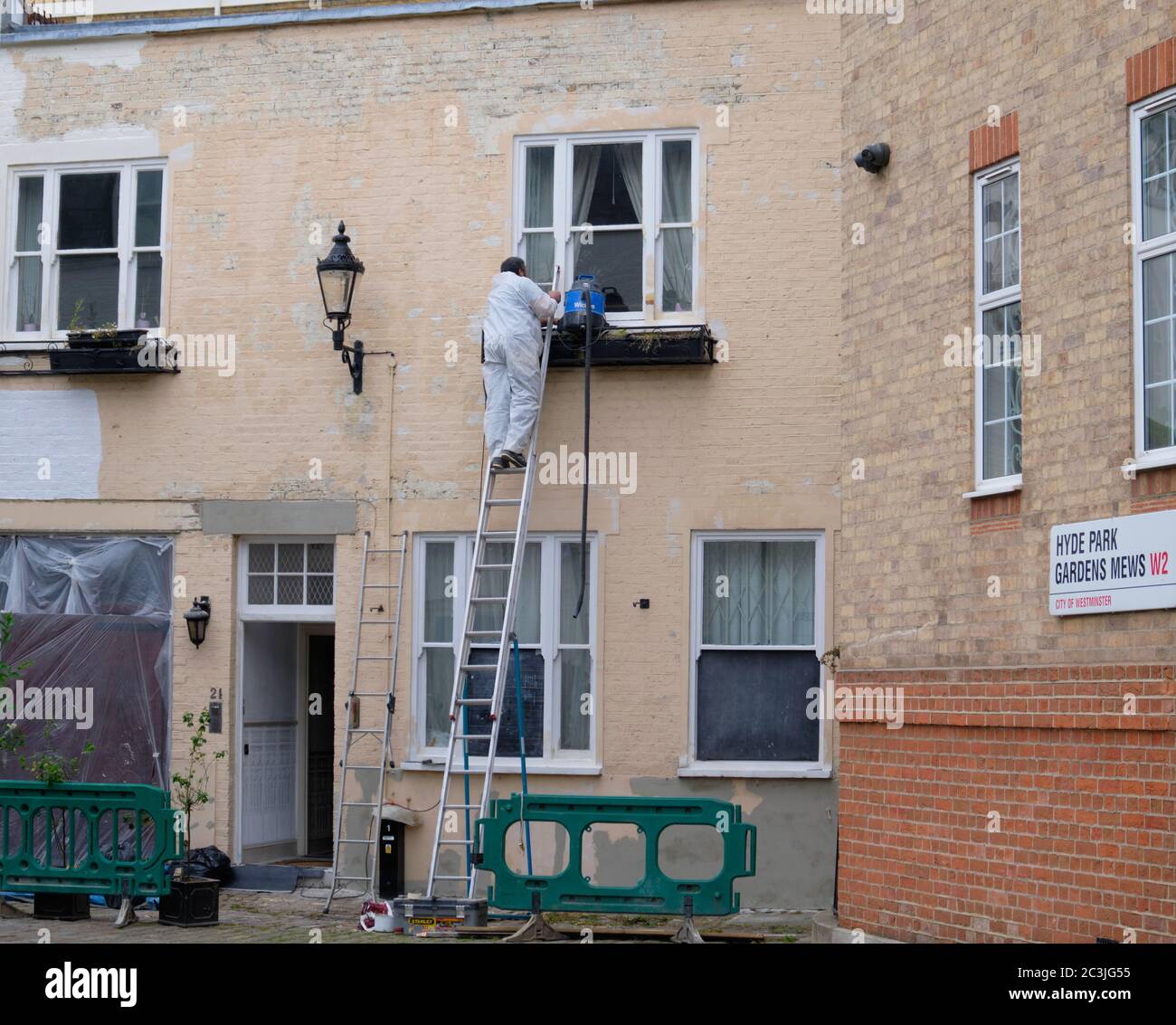Painter on a ladder painting Stock Photo - Alamy